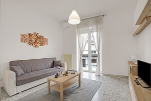 Uma sala de estar moderna com sofá, mesa de centro e obra de arte na parede.