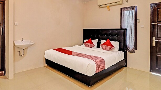 Quarto com uma cama, pia e porta.