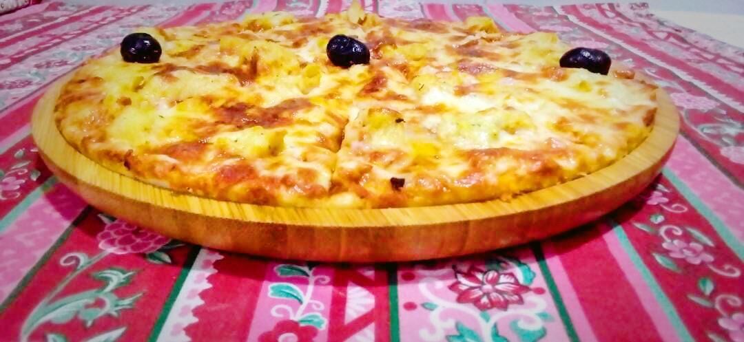 Pizza em uma tábua de madeira.