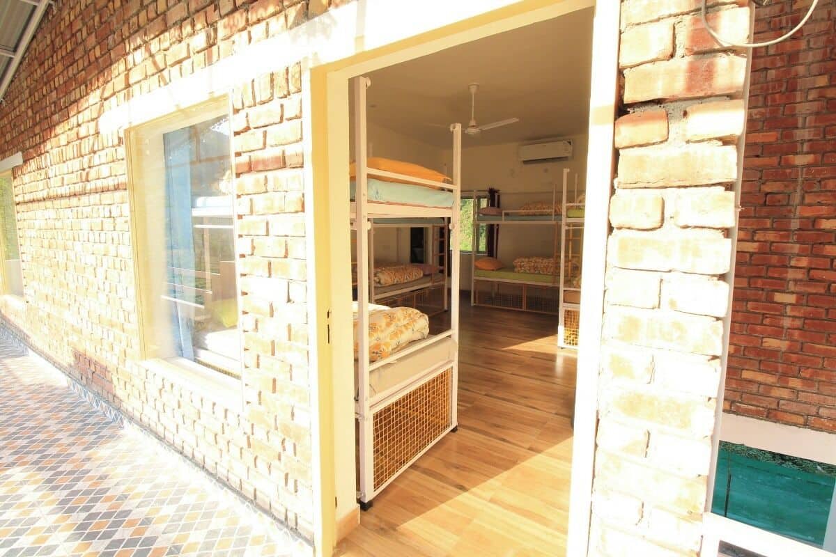 Quarto com fachada de tijolos, janela e piso de madeira.