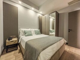Quarto moderno com cama, mesa de cabeceira e guarda-roupa.