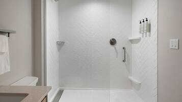Uma casa de banho moderna com chuveiro de vidro, sanita e lavatório.