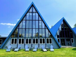 Um edifício moderno com telhado triangular e grandes janelas.