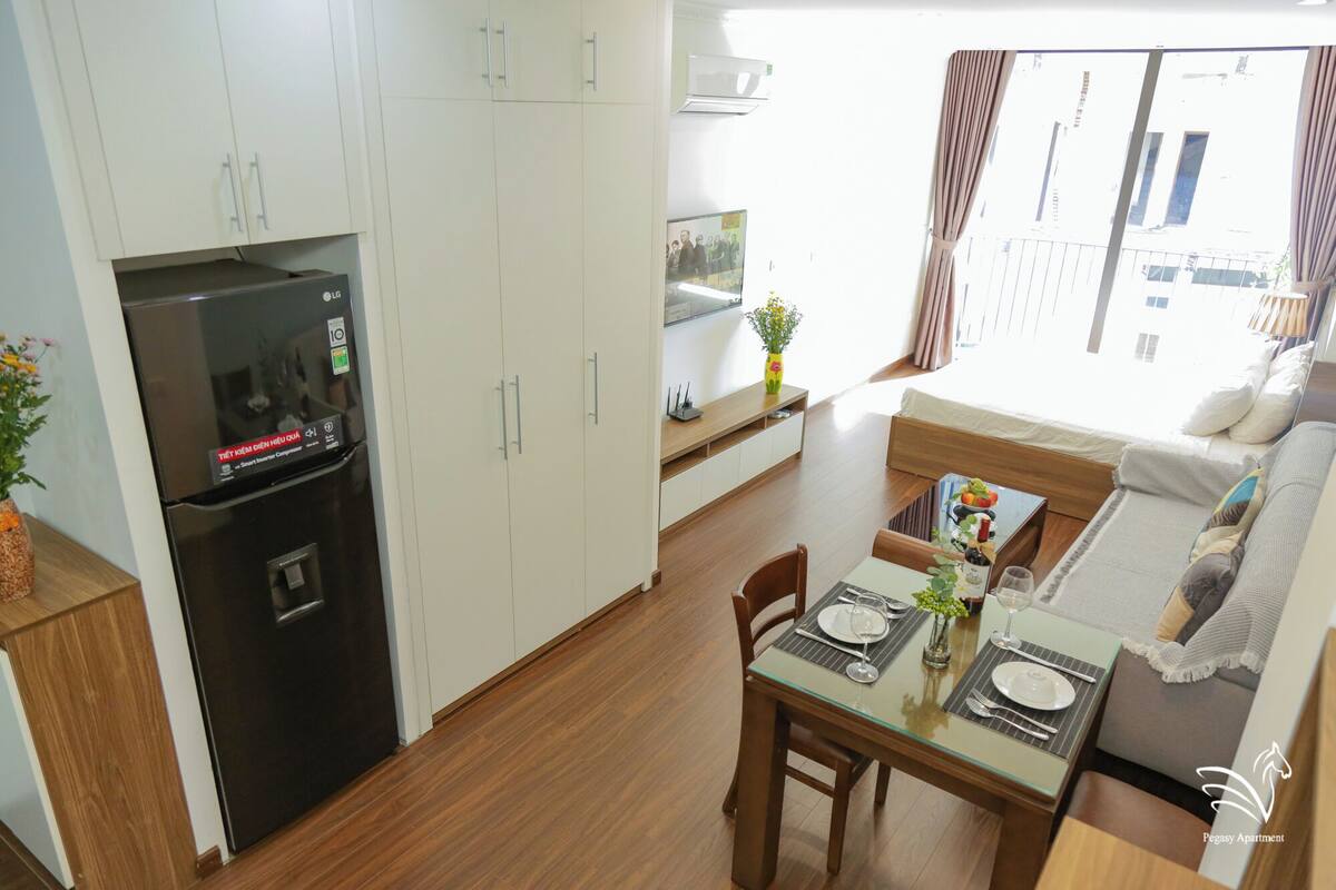 Um espaço compacto para viver, com cozinha compacta, área de refeições e sofá.