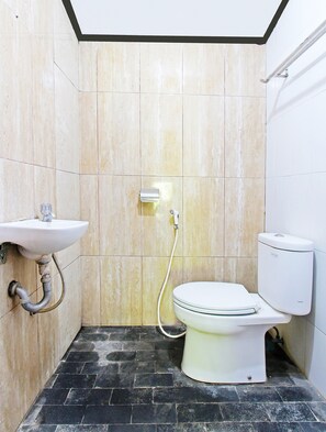 Uma casa de banho pequena com sanita, lavatório e chuveiro.