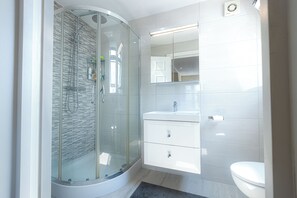 Apartamento, 3 quartos | Casa de banho | Um polibã, um chuveiro fixo, um secador de cabelo, toalhas fornecidas