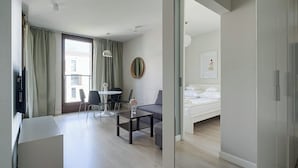 Quarto de hotel moderno com uma cama, uma escrivaninha e um espaço de refeições.