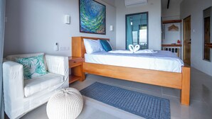 Quarto moderno com cama de madeira, sofá branco e uma grande pintura abstrata na parede.
