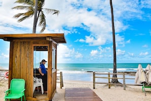 Na praia, areia branca, guarda-sóis