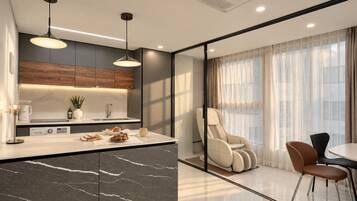 Cozinha moderna com bancada de mármore, forno embutido e área de jantar com divisória de vidro.