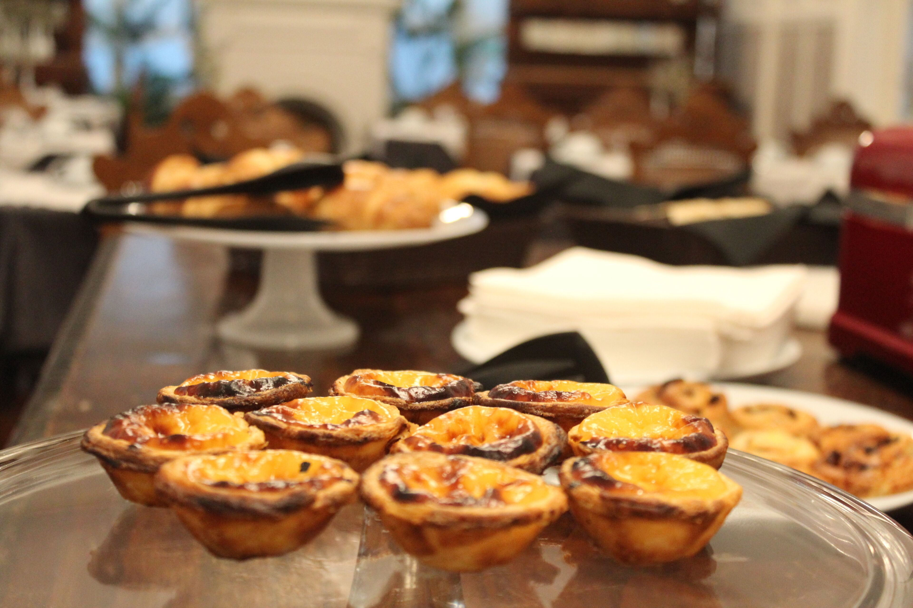 Uma mesa de buffet com diversos doces, incluindo tartes com cobertura de laranja.