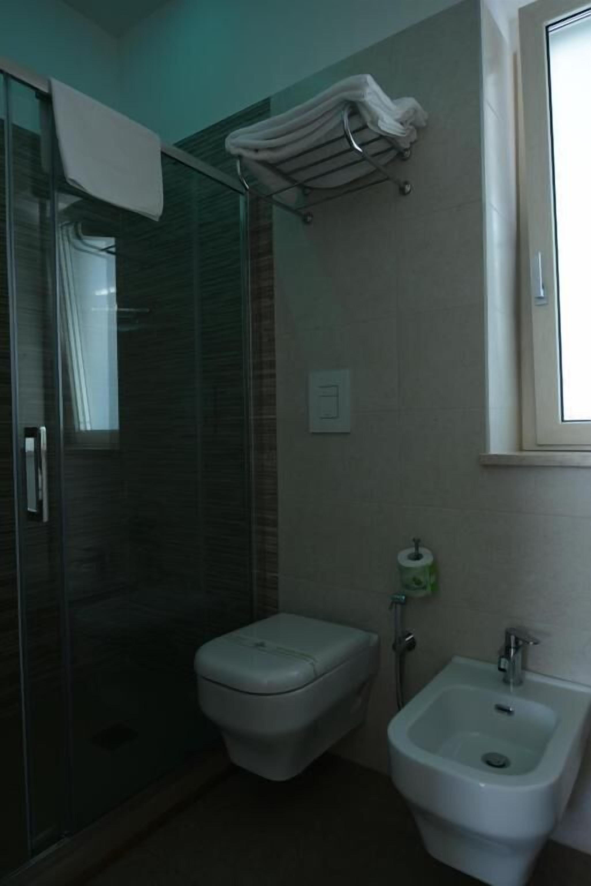 Uma casa de banho moderna com cabine de duche em vidro, sanita e bidé.