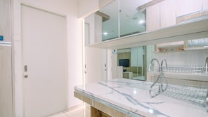 Uma cozinha moderna com bancada de mármore, pia embutida e painel de vidro.