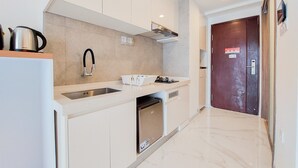 Uma cozinha moderna com máquina de lavar louça embutida, chaleira de aço inoxidável e uma pia.
