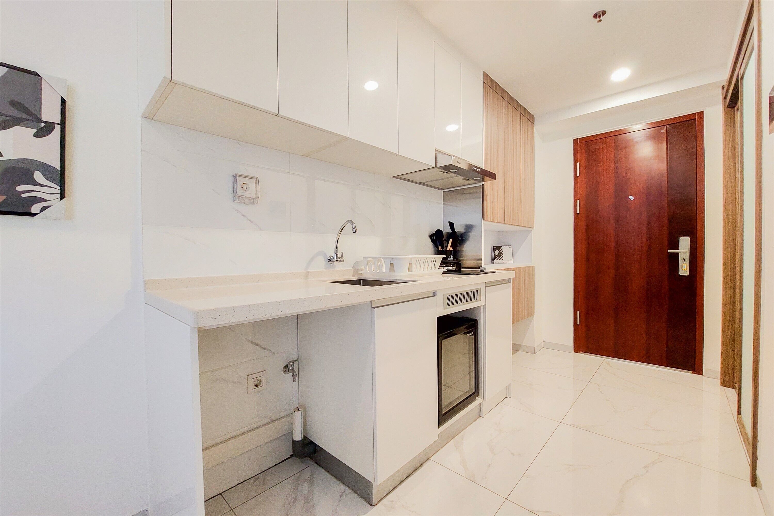 Cozinha moderna com armários brancos, forno embutido e pia.