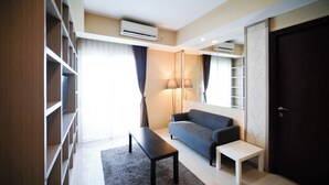 Uma sala de estar moderna com sofá, mesa pequena, banco, guarda-roupa e uma porta.