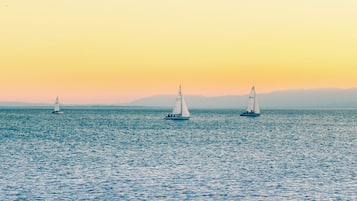 Três veleiros em um mar calmo sob um céu claro.