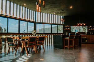 Uma cozinha moderna com uma ilha grande, banquetas para bar e vista para o exterior.