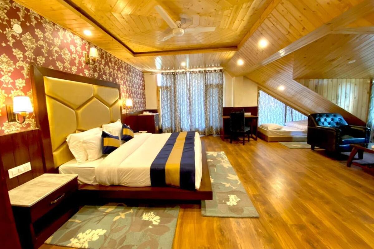Um quarto espaçoso com uma cama grande, uma escrivaninha e um sofá.