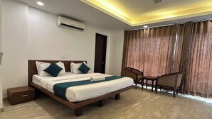 Quarto de hotel moderno com uma cama grande, uma escrivaninha e uma cadeira.