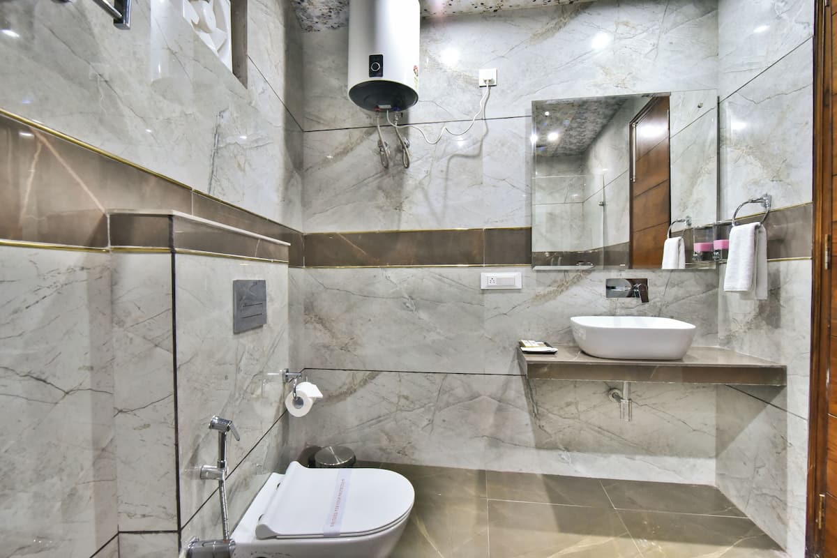 Uma casa de banho moderna com sanita, lavatório e chuveiro.
