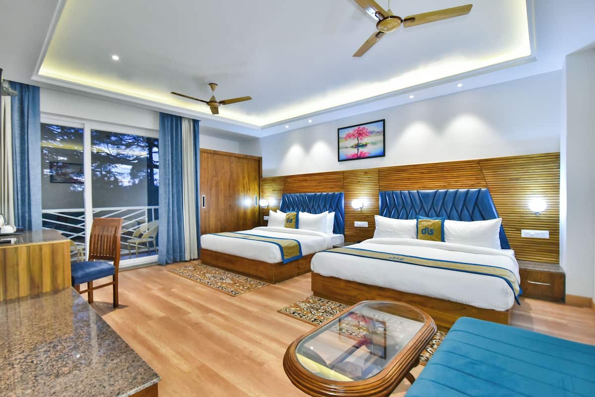 Quarto de hotel com duas camas, área de estar, varanda e área de jantar.
