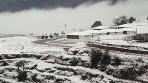 Paisagem nevada com edifícios e uma linha férrea.