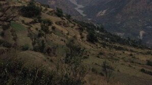 Paisagem montanhosa com um vale e um rio.