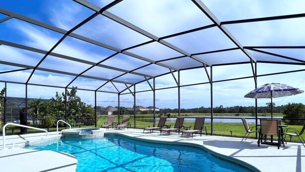 Piscina coberta com vista para a paisagem, cadeiras de descanso e área de varanda.