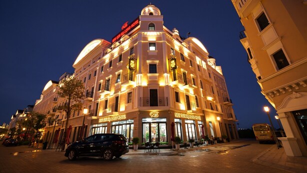Um hotel com estilo arquitetônico clássico, apresentando uma cúpula imponente e várias varandas.