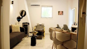 Uma sala de estar moderna com sofá, poltronas, mesa de centro e um espelho.