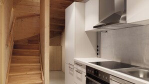 Uma cozinha moderna com vigas de madeira, eletrodomésticos de aço inoxidável e armários brancos.