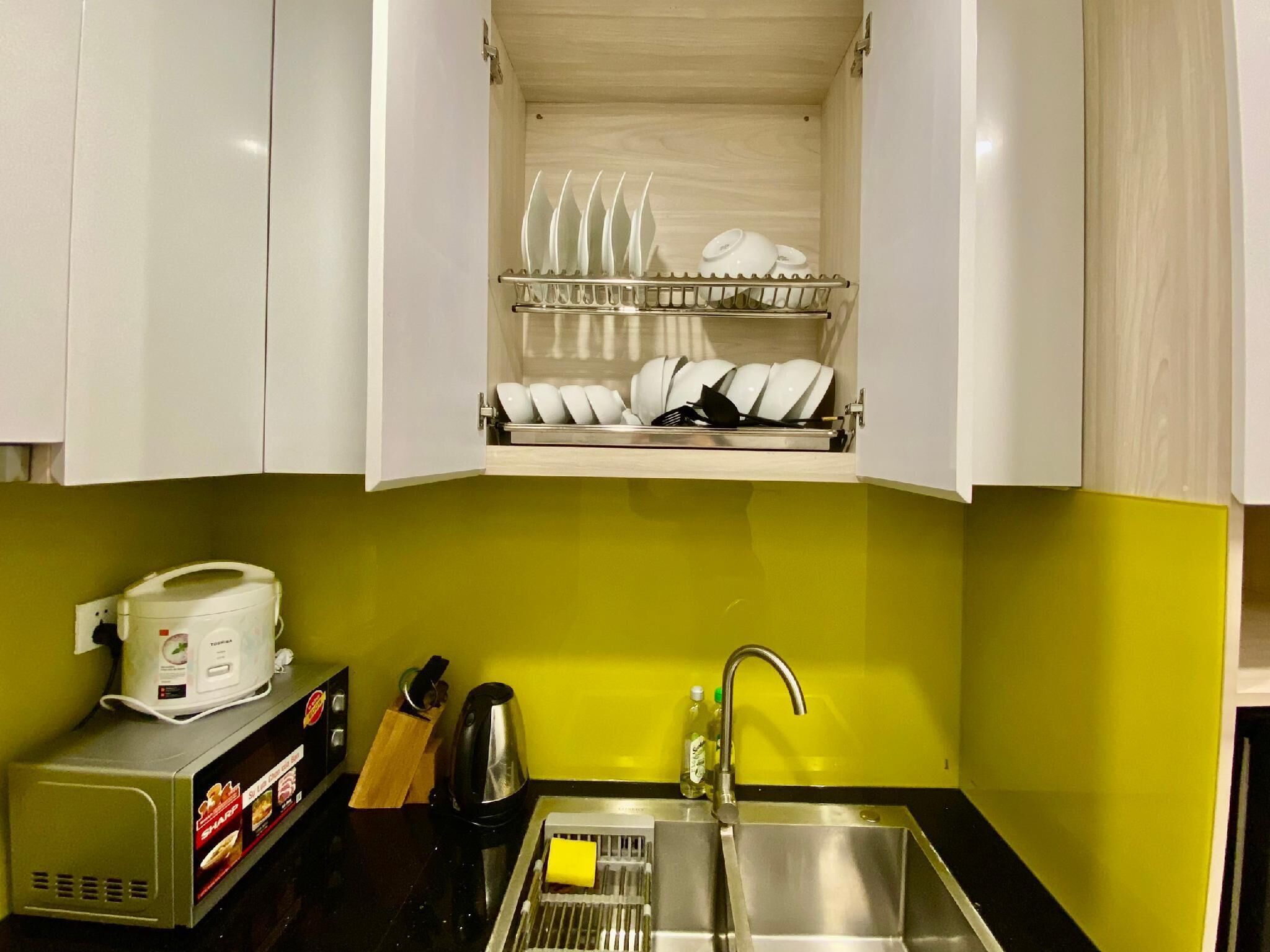 Uma cozinha com escorredor de louça, chaleira e cafeteira.