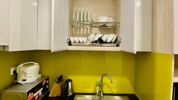 Uma cozinha com escorredor de louça, chaleira e cafeteira.