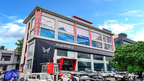 Um edifício moderno com o logotipo da Mahindra, com grandes janelas e uma entrada imponente.