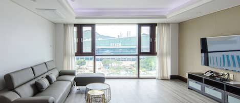 Uma sala de estar moderna com sofá, mesa de centro e televisão.