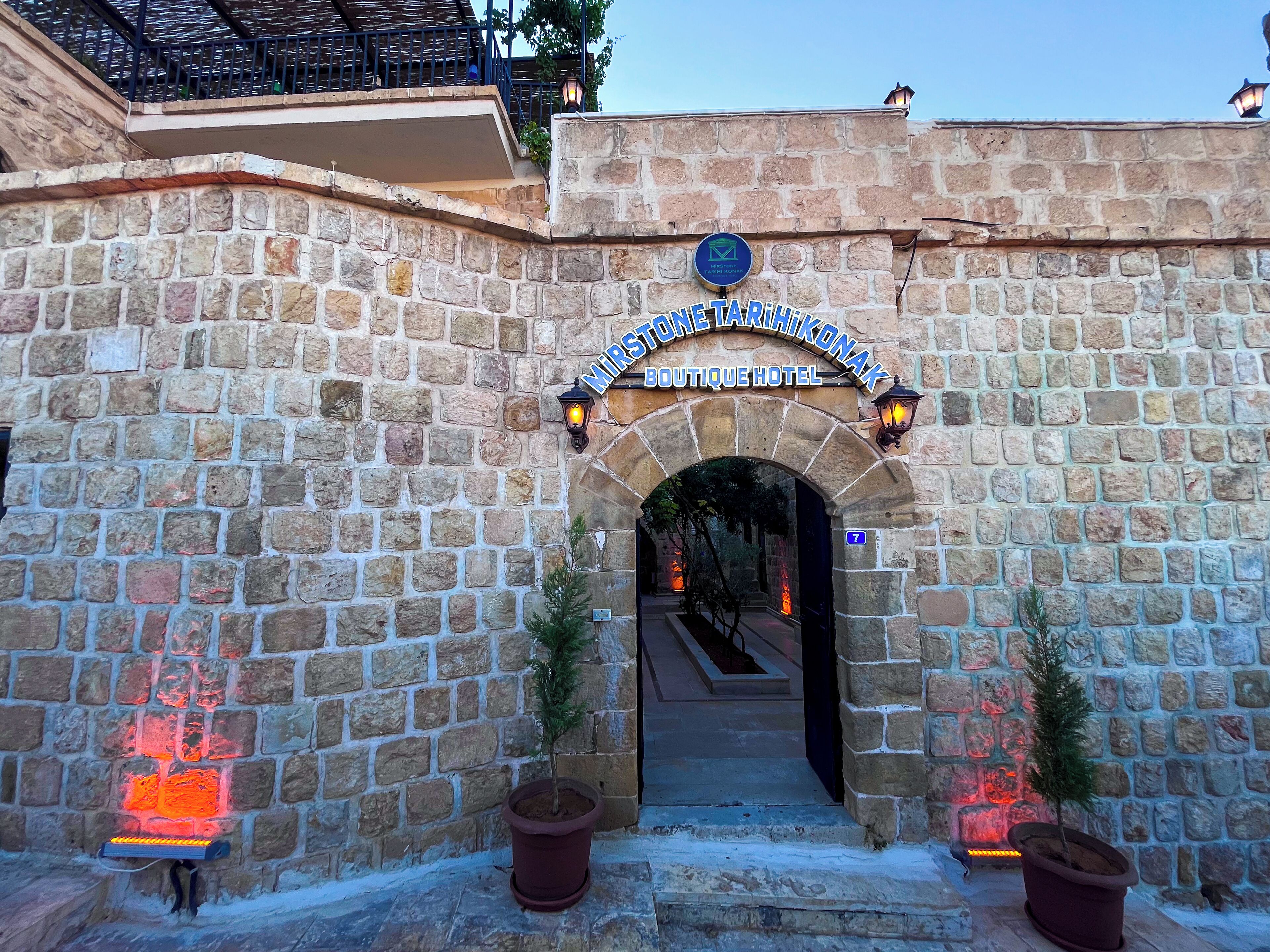 Um arco de pedra com a placa "MRS. STONE TARIHKONAK BOUTIQUE HOTEL" acima.