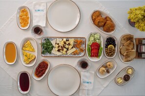 Uma mesa posta com vários pratos, incluindo queijo, pão e legumes.