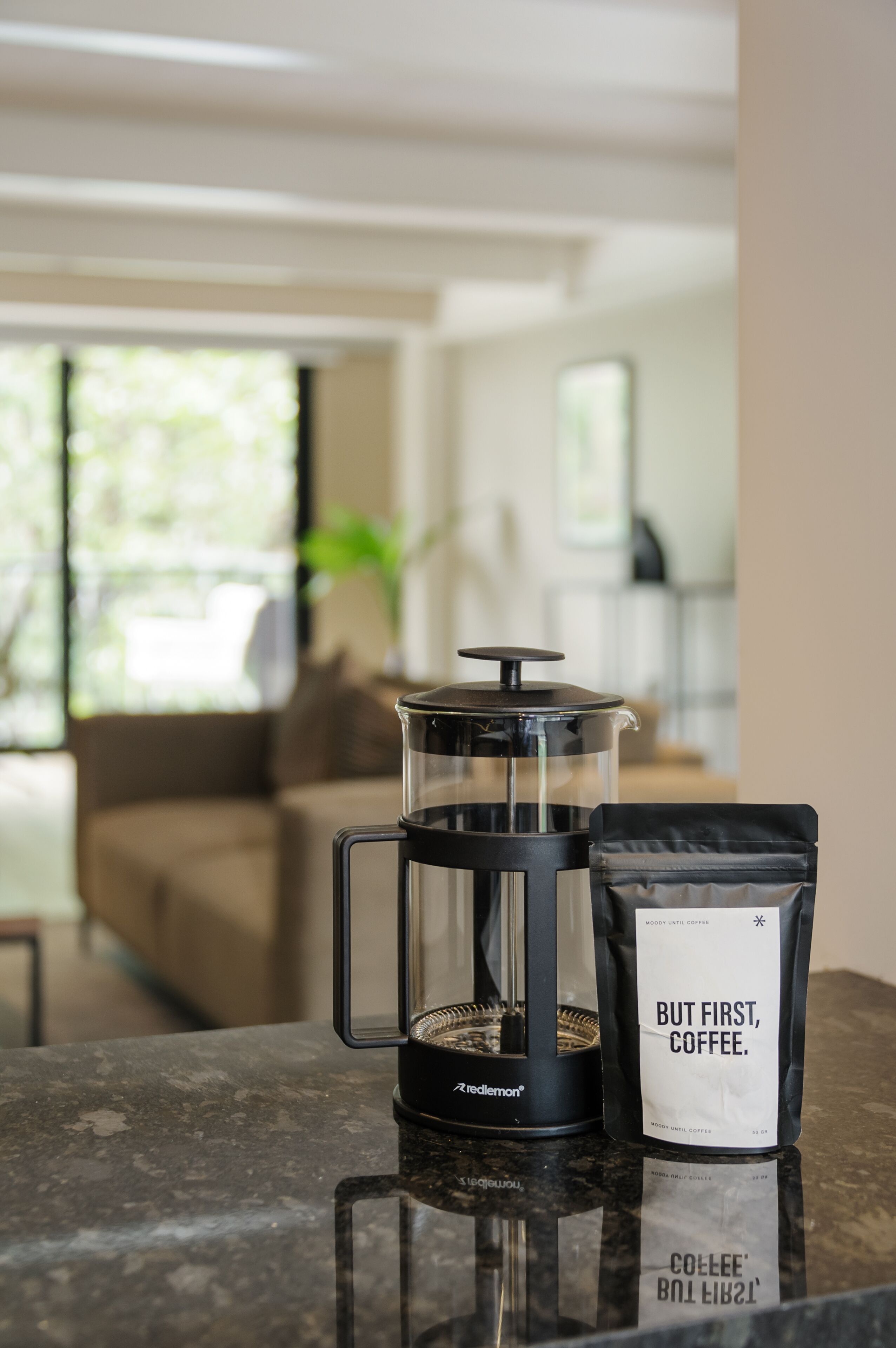 Máquina de café e um saco de café em uma bancada de cozinha.