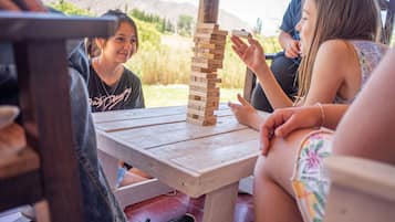 Um grupo de pessoas jogando um jogo de blocos de madeira em uma mesa de madeira ao ar livre.