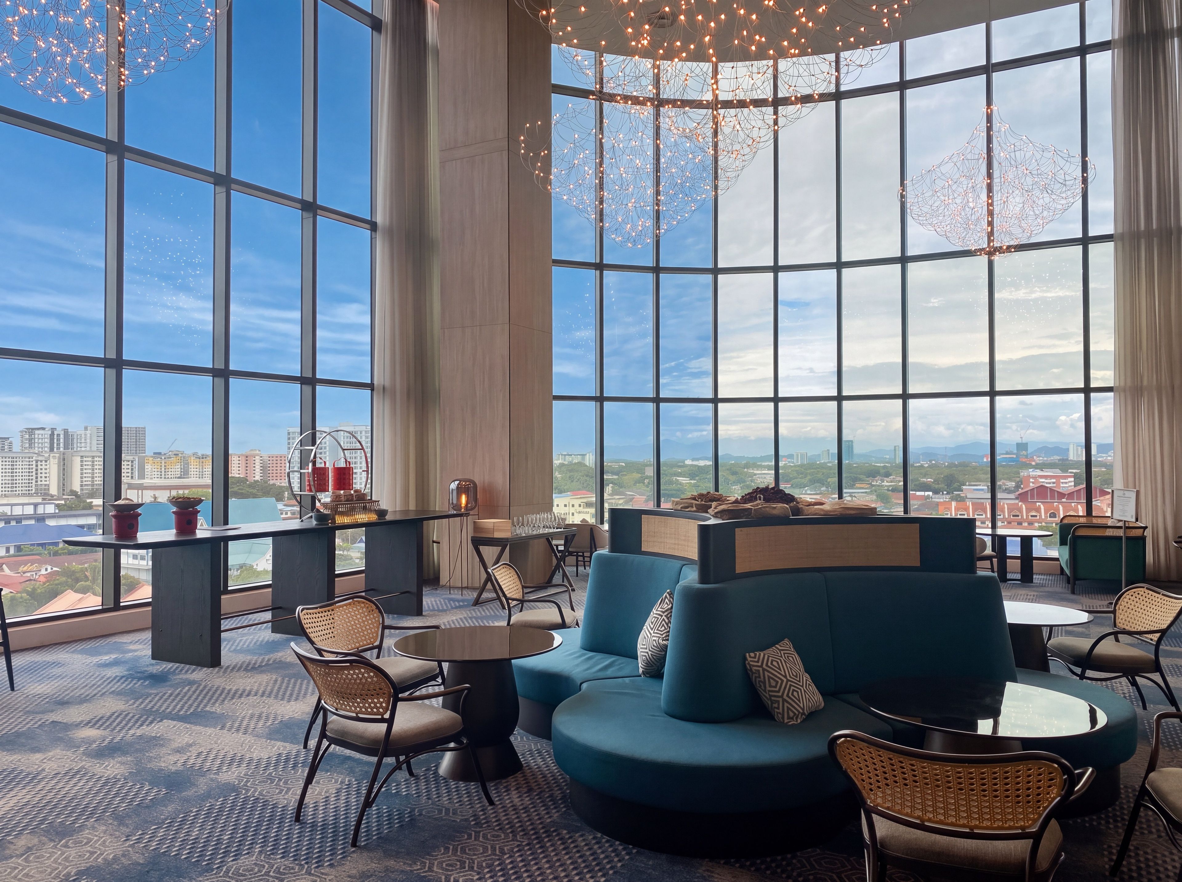 Um lounge moderno com grandes janelas, áreas de estar e vista para a cidade.