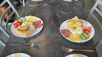 Uma mesa de jantar com vários pratos de comida, incluindo sanduíches, ovos e legumes.