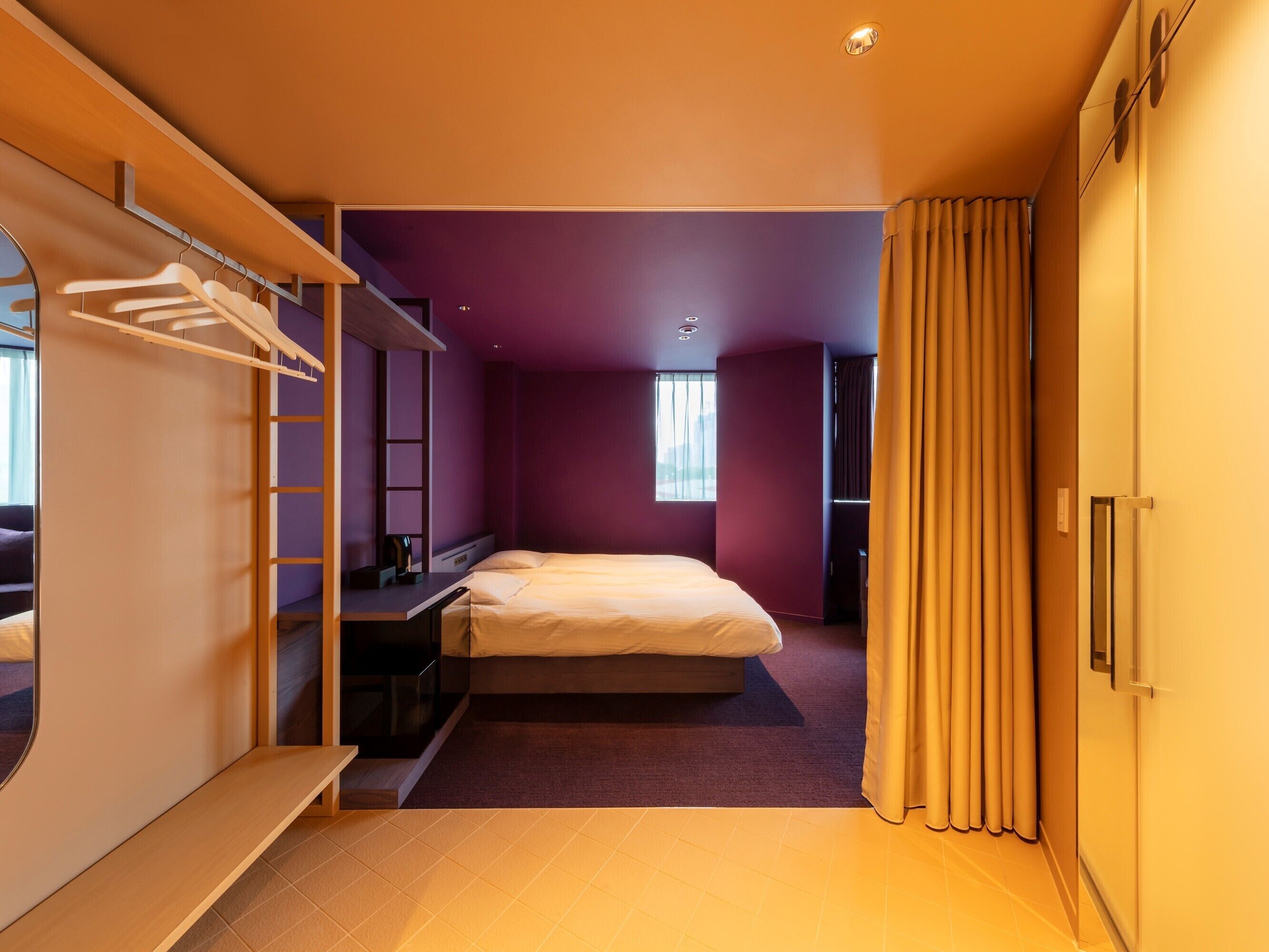 Quarto com cama, guarda-roupa, escrivaninha e espelho.