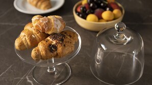 Uma mesa com sobremesas, doces e uma cesta de frutas.