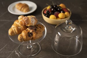 Uma mesa com sobremesas, doces e uma cesta de frutas.