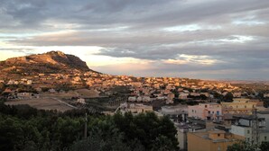 Uma cidade costeira com edifícios, uma colina e uma ponte.