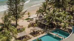 Um resort com piscina, praia e palmeiras.