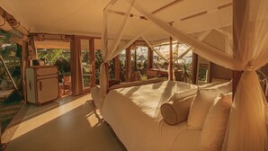 Quarto com cama de dossel, um pequeno armário e vista para o exterior.