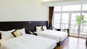Quarto de hotel com duas camas, uma janela ampla com vista e um design moderno no teto.