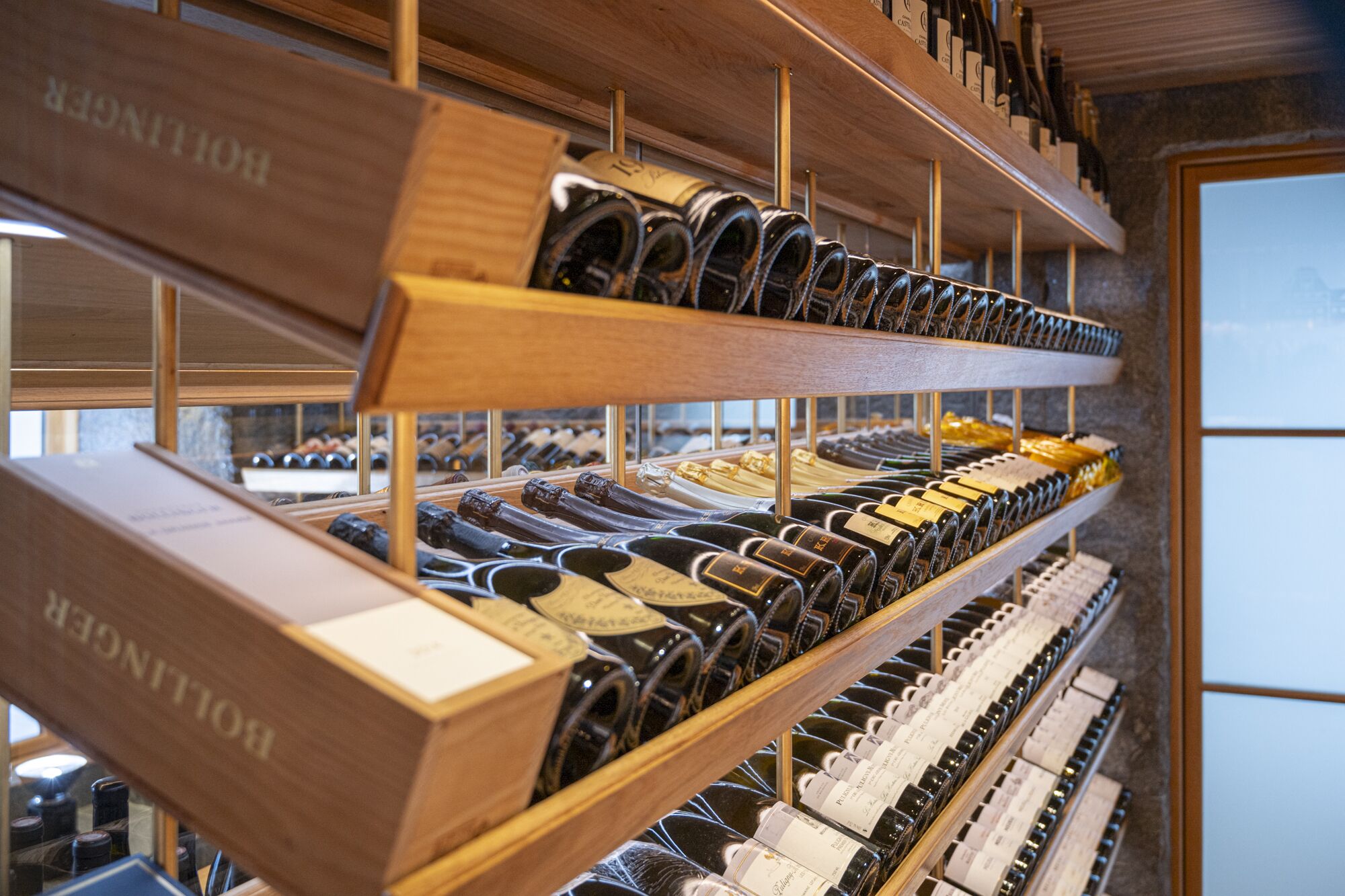 Uma adega com várias estantes de madeira repletas de garrafas de vinho.